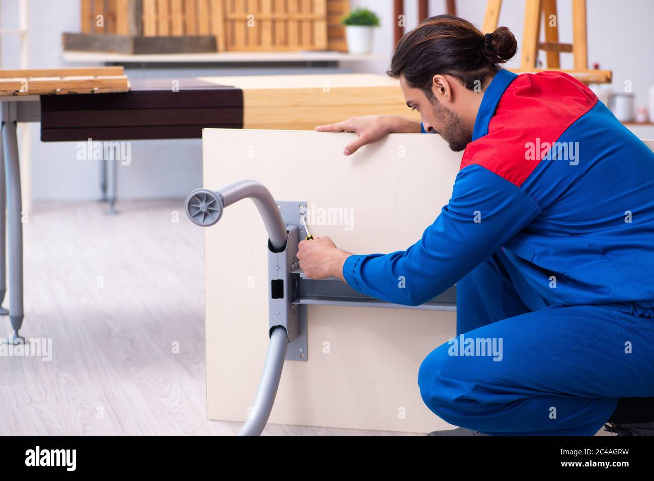 Young male contractor working in the workshop Stock Photo - Alamy