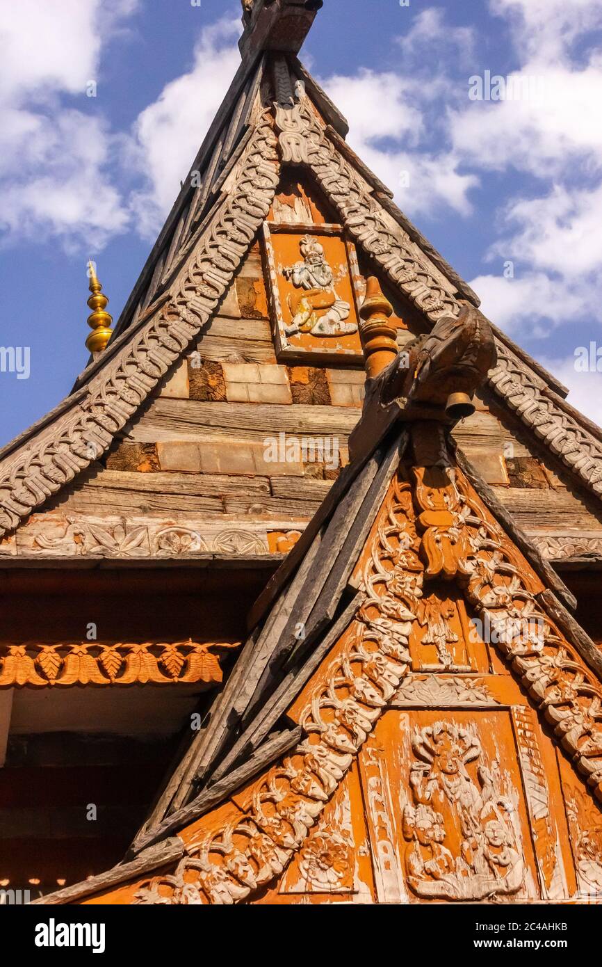 The wooden gabled roofs with ornate carvings of mythological deities in ...