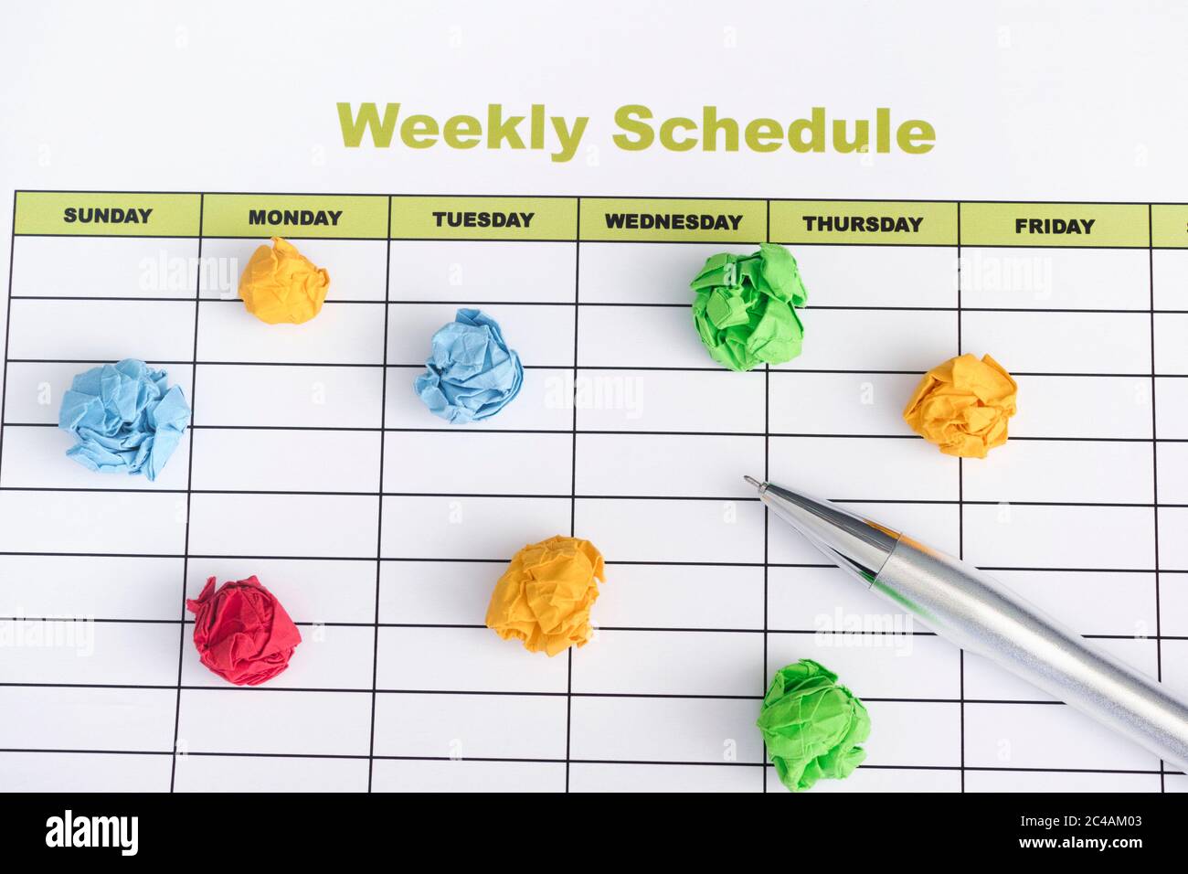 Daily schedule with pen and colorful crumpled paper balls. Close up ...
