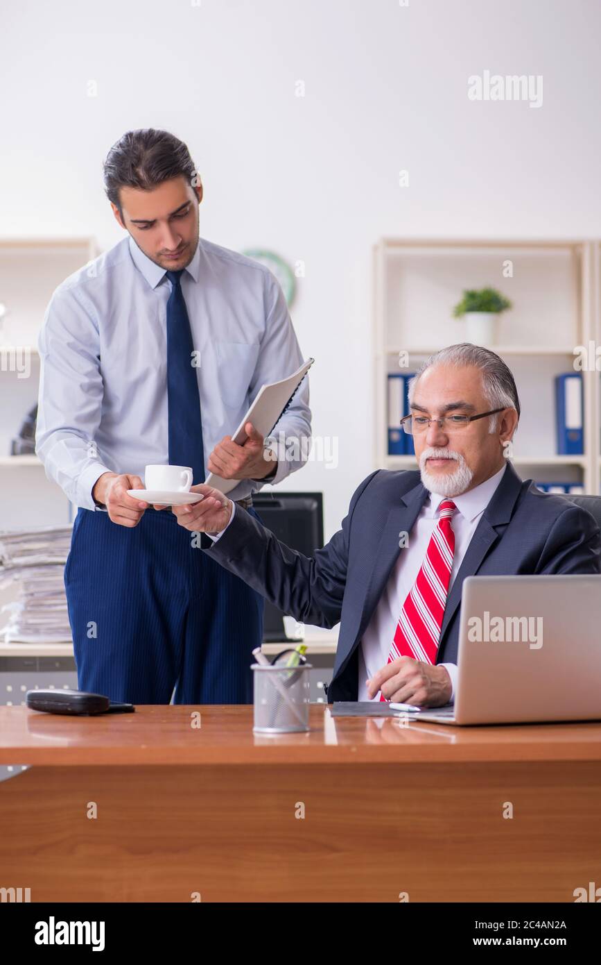 Old boss and young employee in the office Stock Photo - Alamy