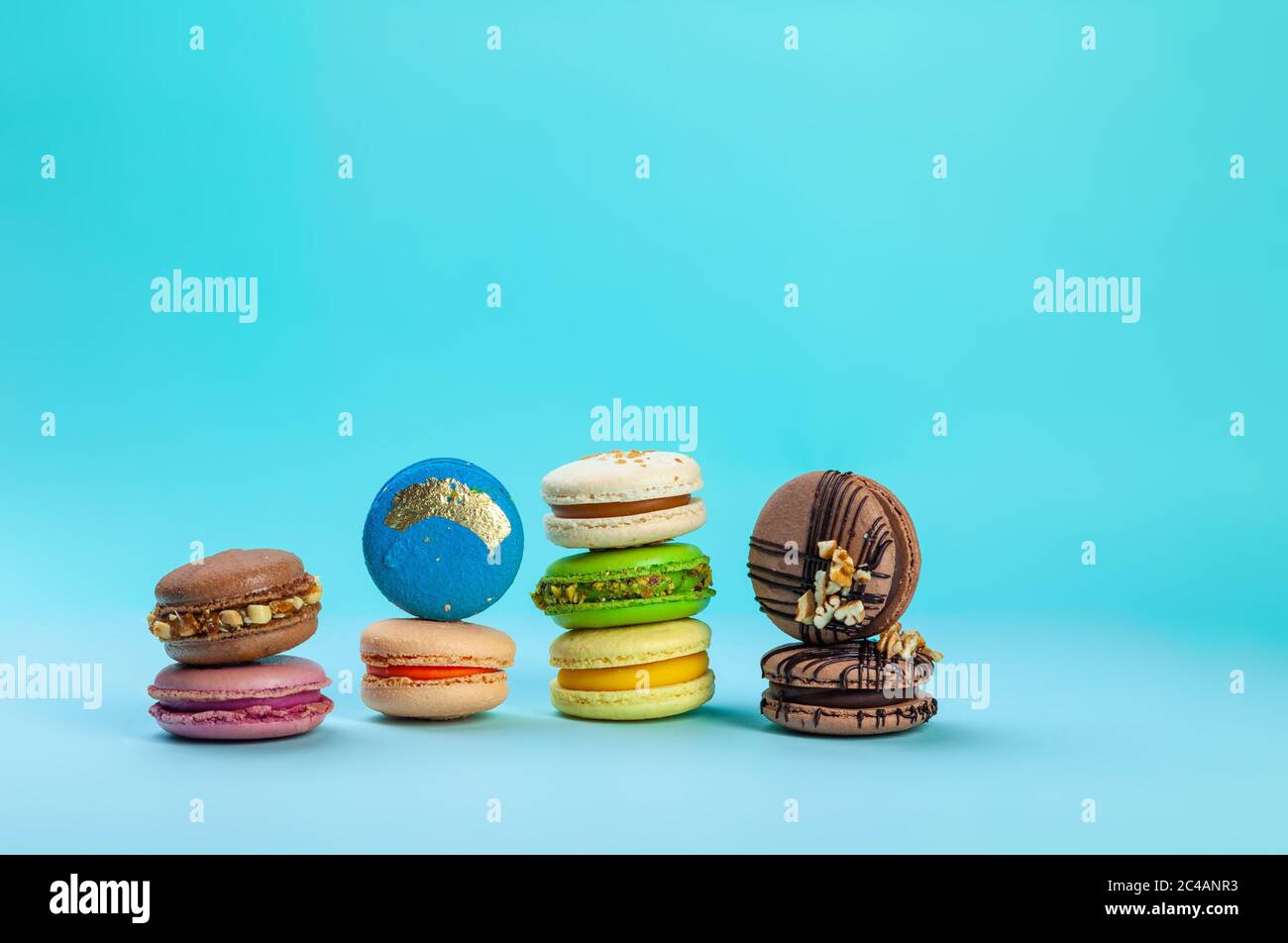 Different types of colorful sweet macaroons dessert on blue background ...