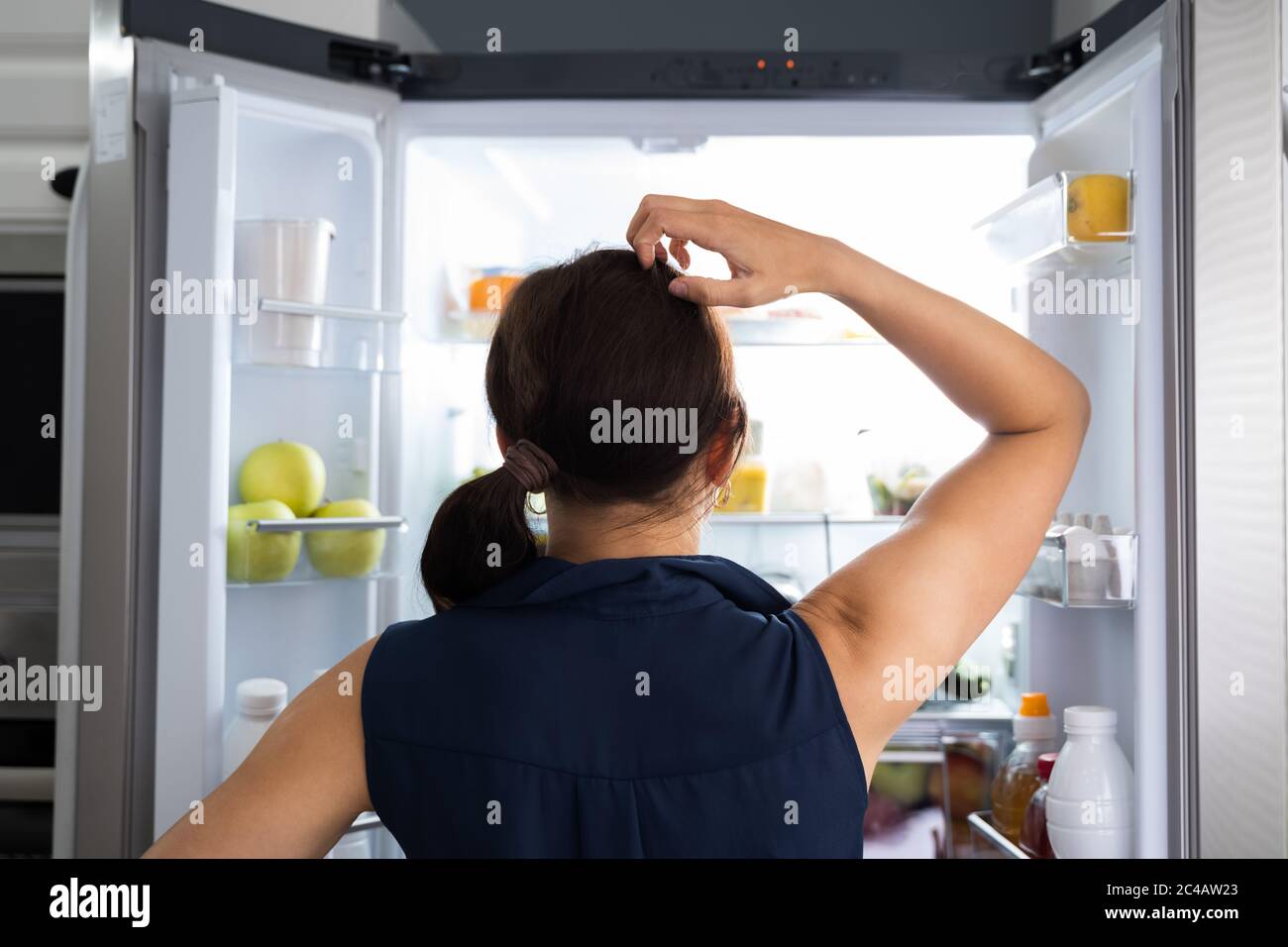 Girl looking into fridge hi-res stock photography and images - Alamy