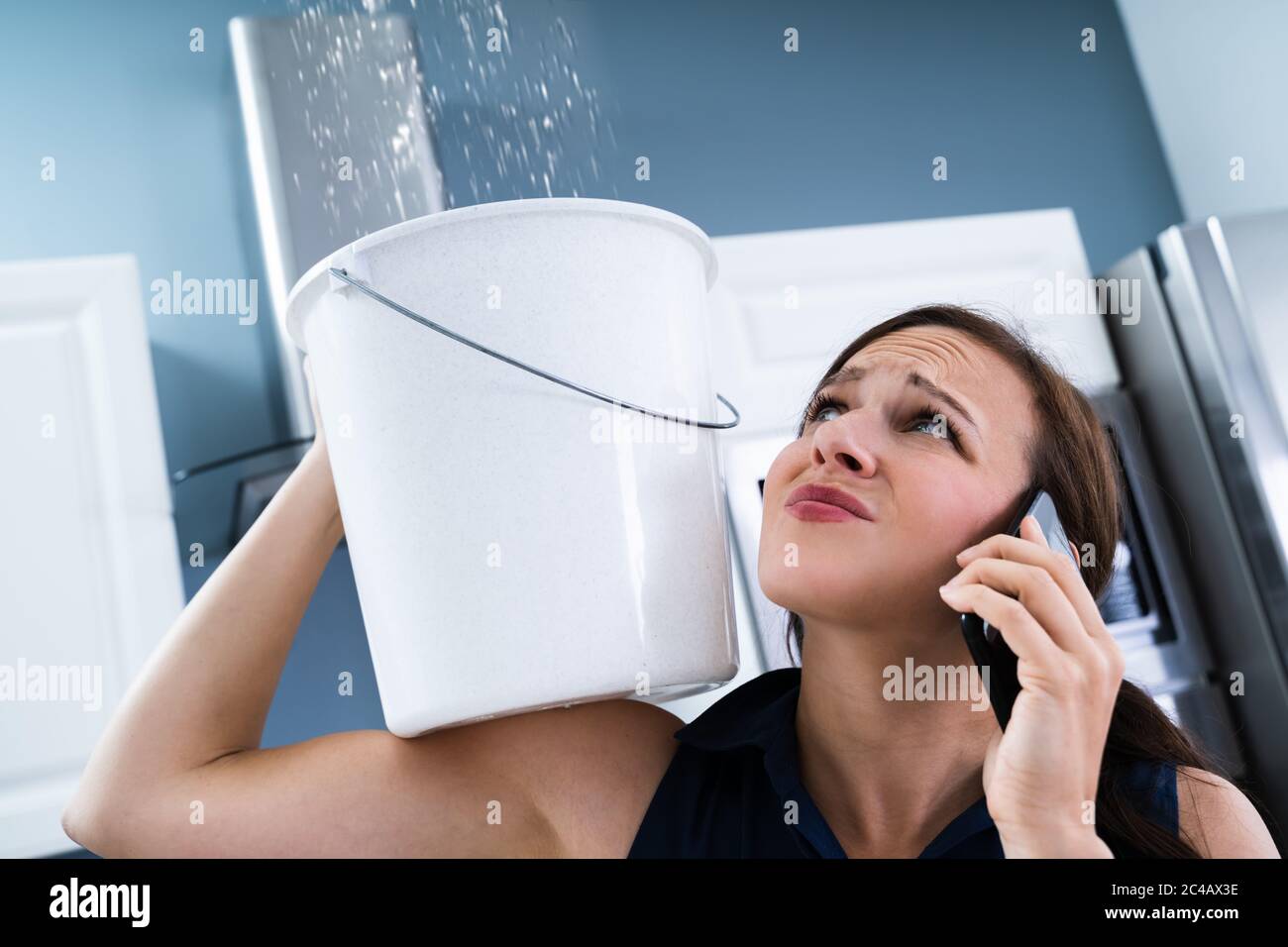 Worried Woman Holding Bucket While Water Droplets Leak From Ceiling In ...