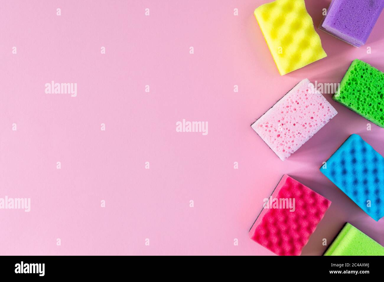 Multi-colored cleaning sponges on a pink background, housekeeping and ...