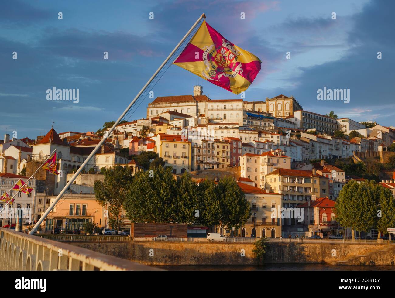 Coimbra, Portugal seen across the Mondego river. The flag is of the ...