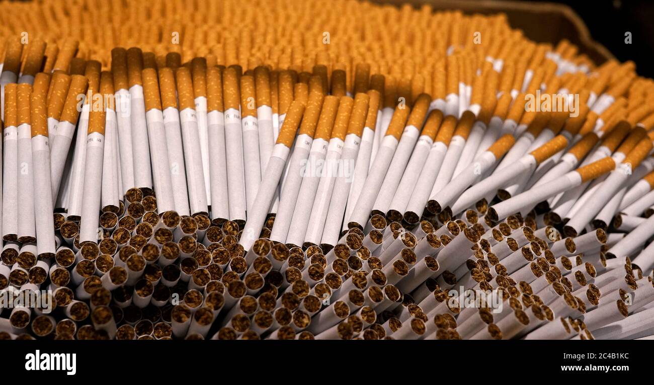 Many loose cigarettes background Stock Photo - Alamy