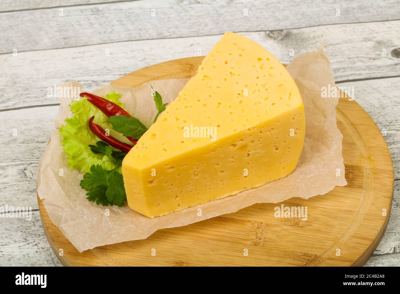 Piece. of Yellow Cheese served herbs Stock Photo - Alamy