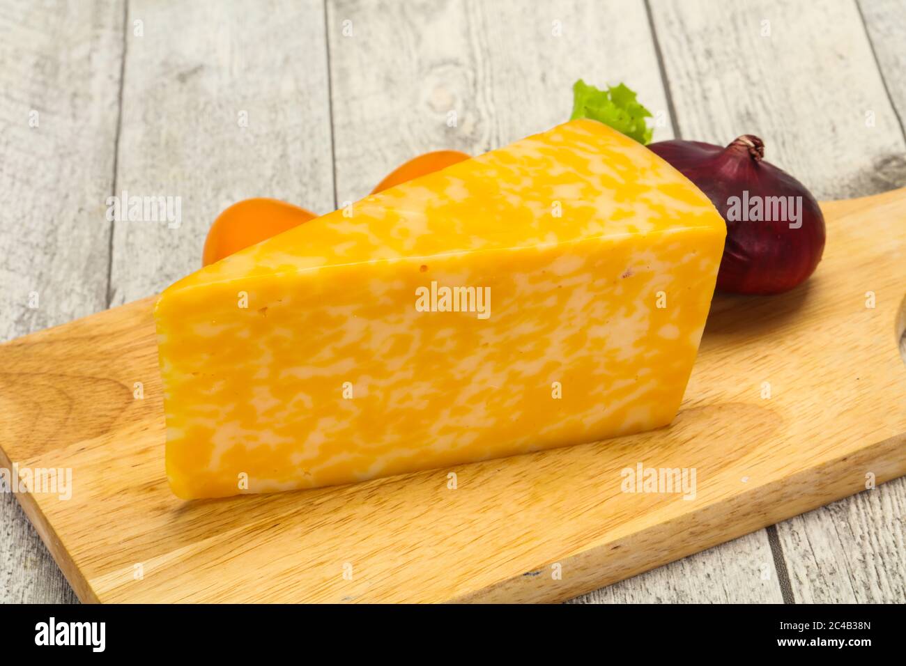 Marble cheese triangle over wooden background Stock Photo - Alamy