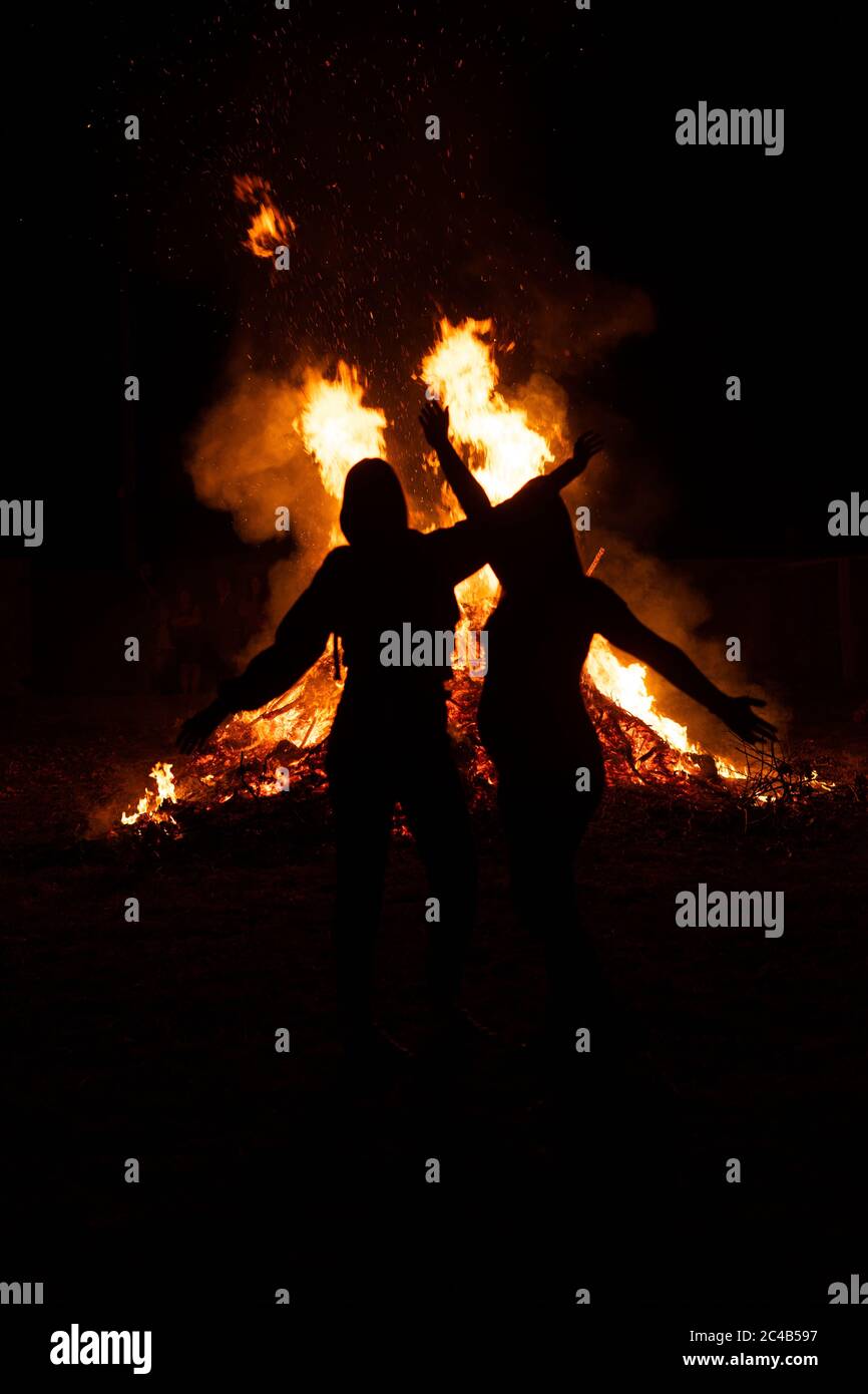 two friends in front of a giant fire Stock Photo - Alamy