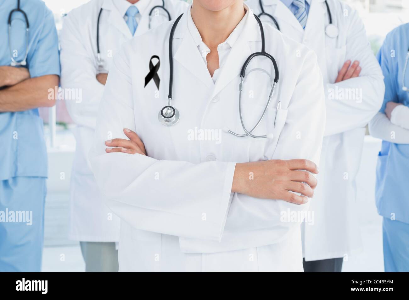 Mid section of team of doctors with black ribbon standing with their ...