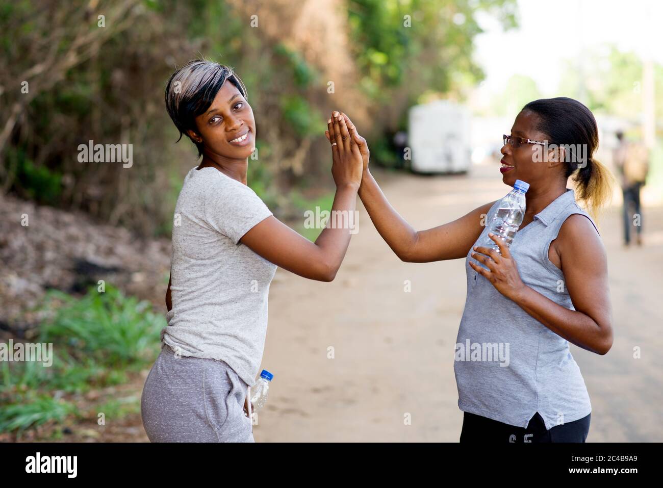 Young women standing saluting after sport smiling Stock Photo - Alamy