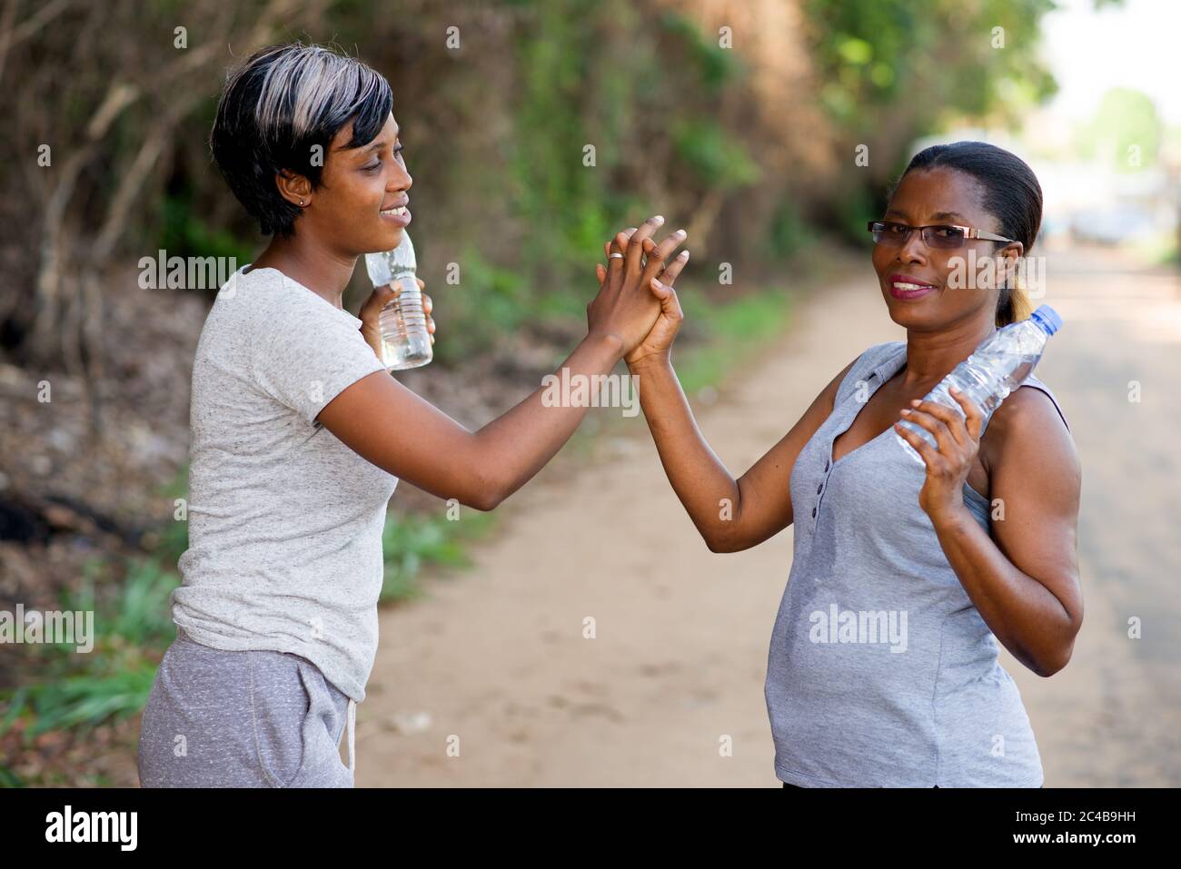 Young women standing saluting after sport smiling Stock Photo - Alamy