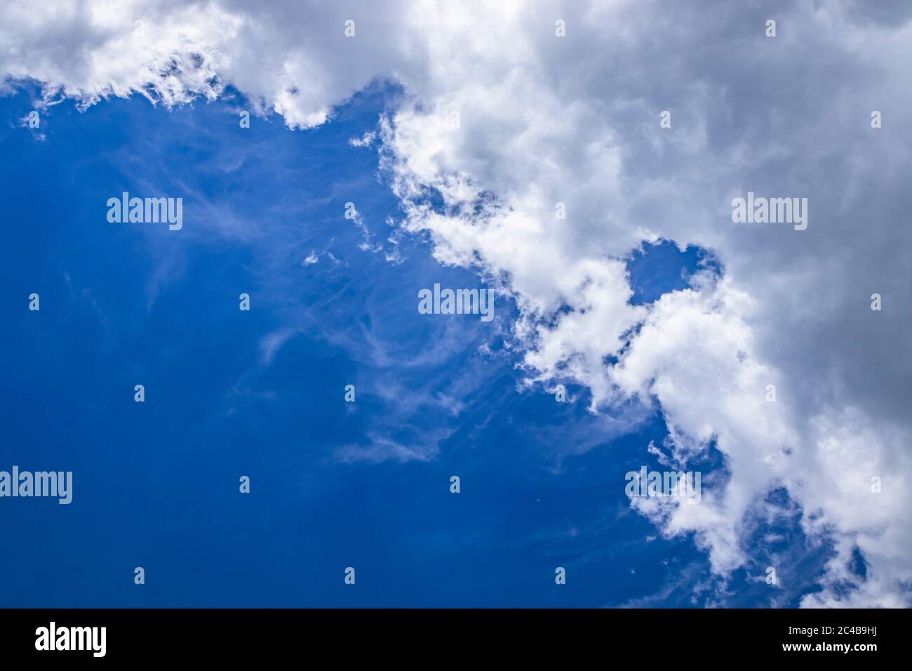 The white clouds rip apart letting you see the blue sky on a summer day ...