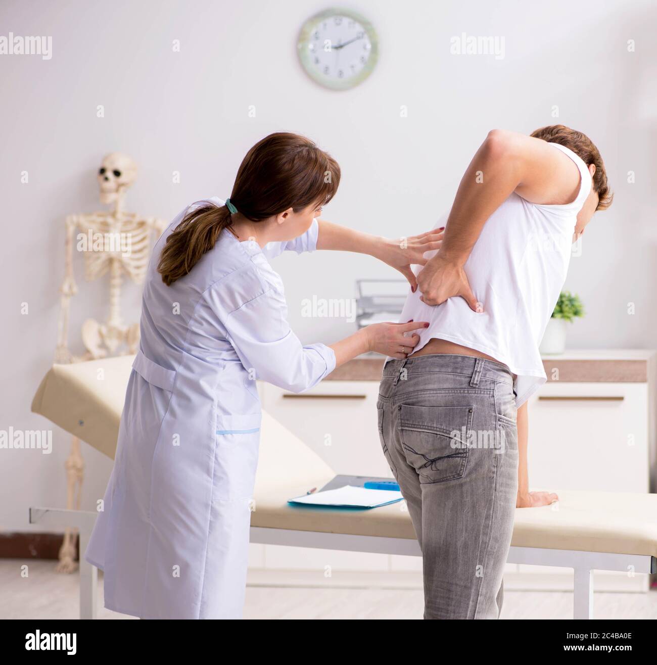 The male patient visiting young female doctor chiropractor Stock Photo ...