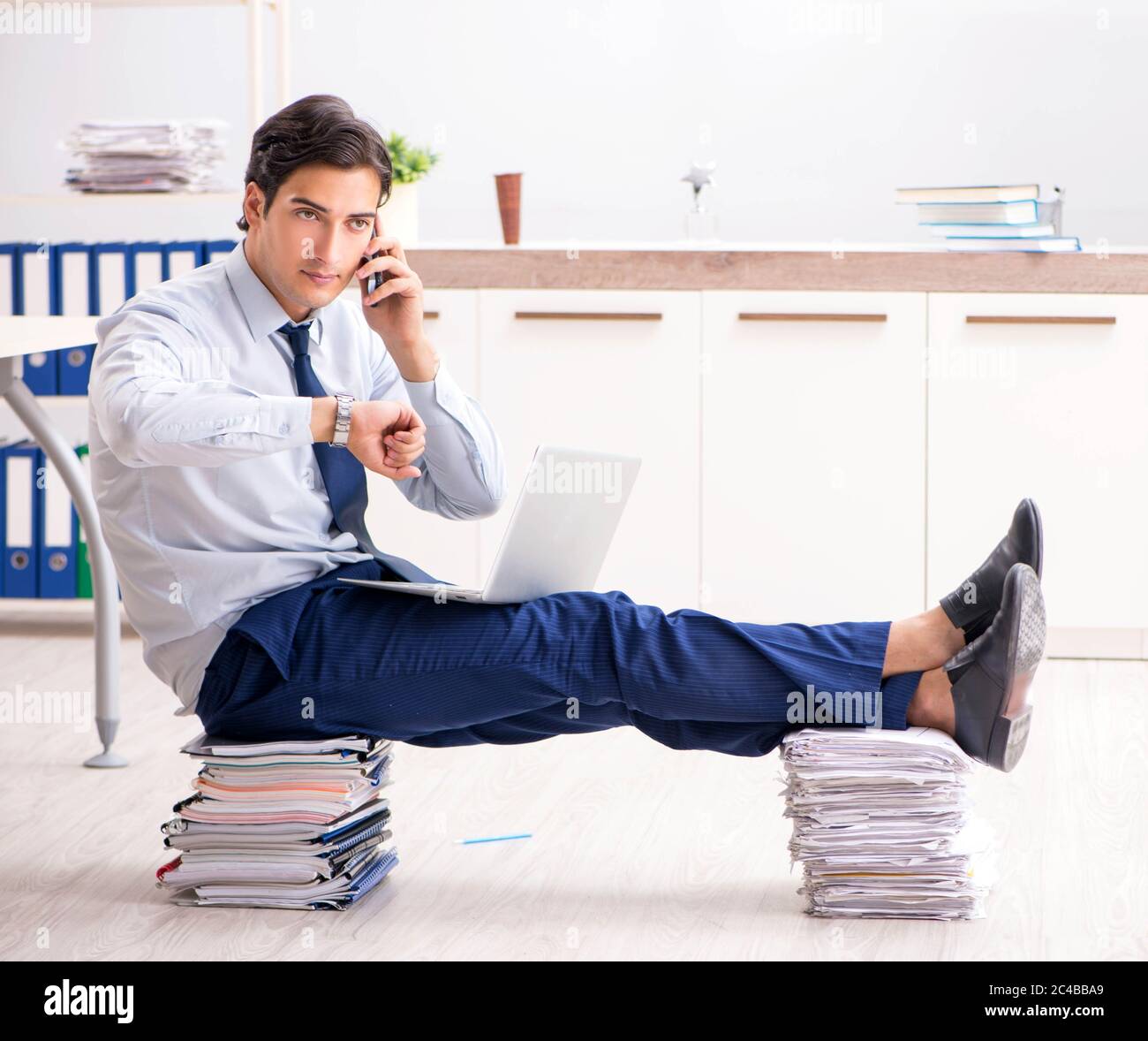 The extremely busy employee working in the office Stock Photo - Alamy