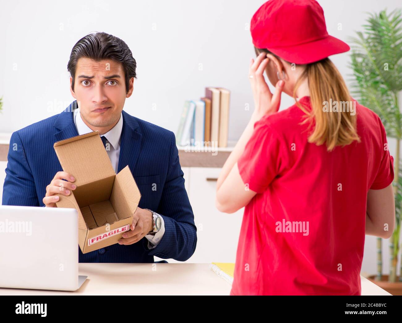 The courier delivering parcel to the office Stock Photo - Alamy