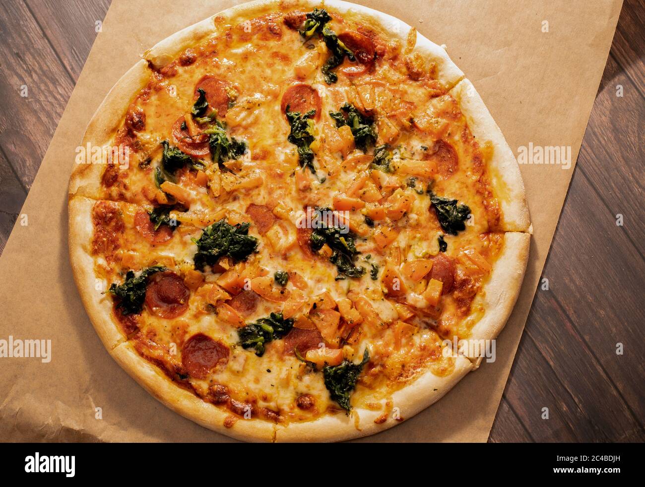 Whole italian pizza with tomatoes, cheese and spinach Stock Photo - Alamy