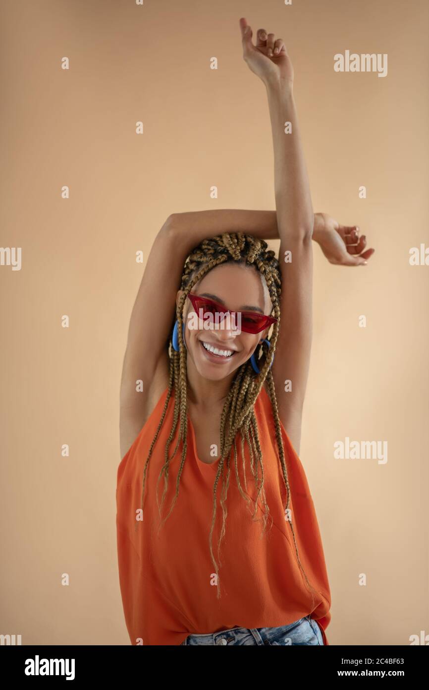 Smiling young African American raising her hands above her head Stock ...
