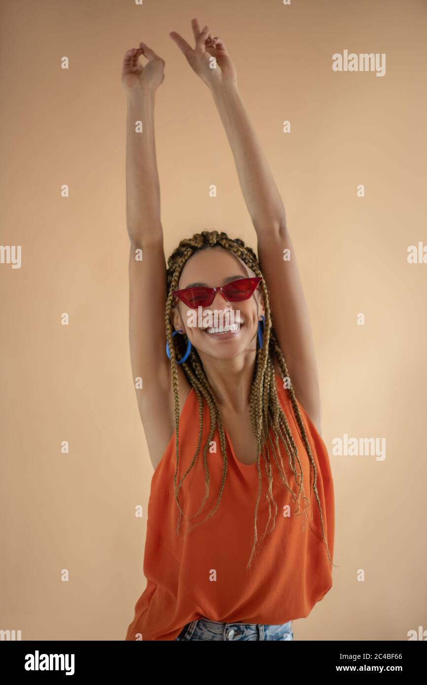 Smiling young African American raising her hands above her head Stock ...