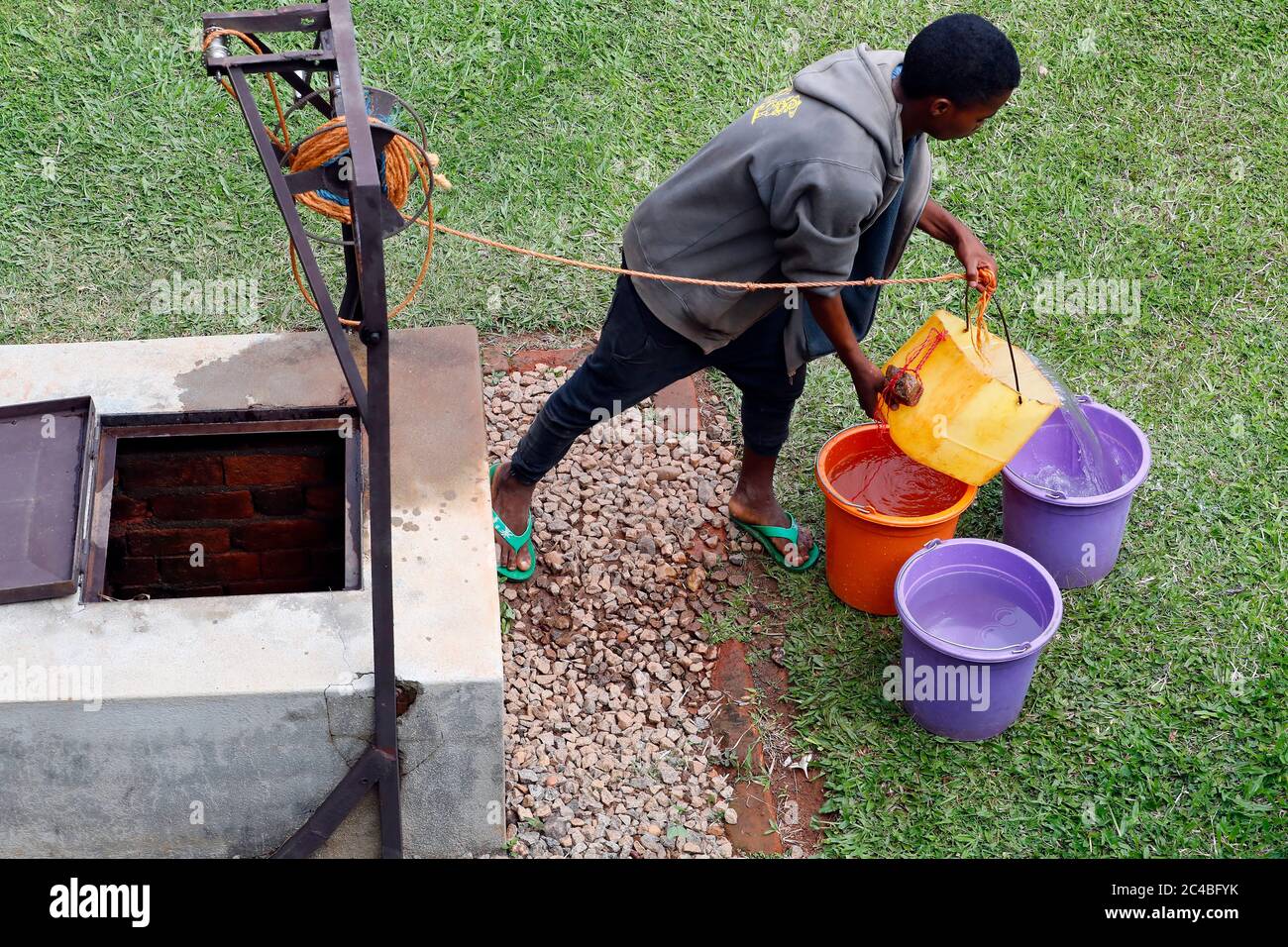 Boy drawing water from a well Stock Photo - Alamy