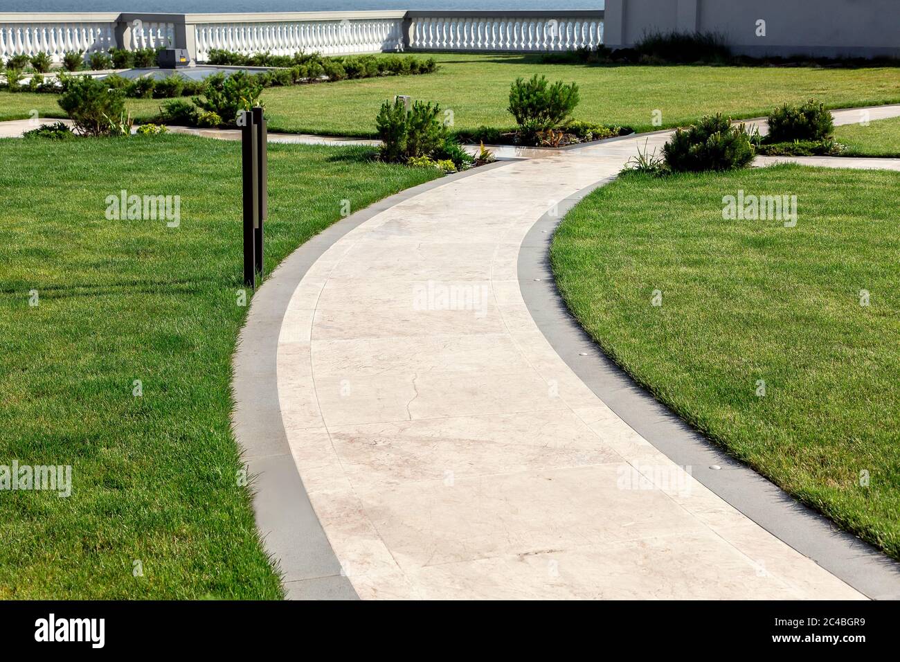 marble walkway in the backyard park with a green lawn and balustrades ...