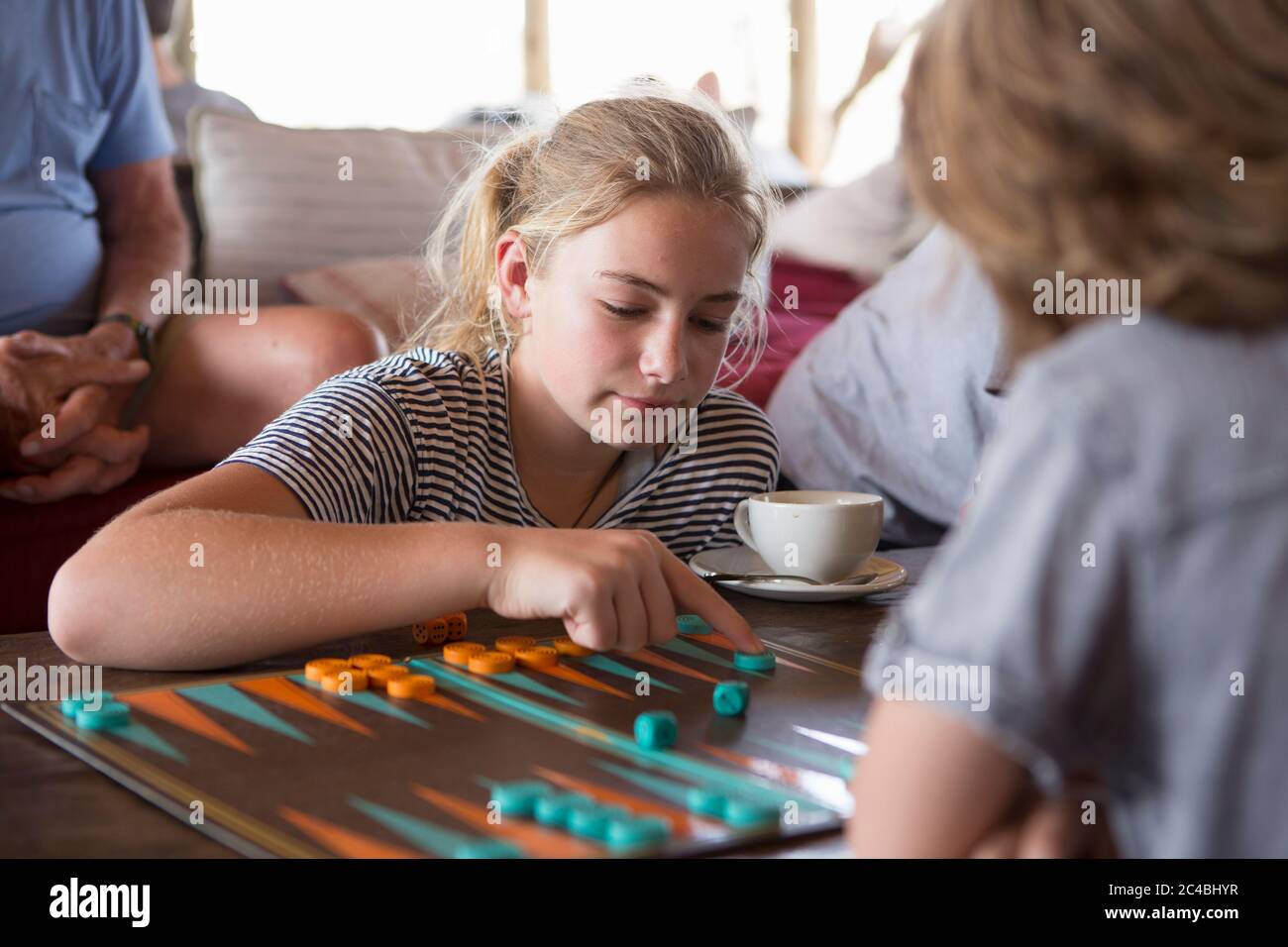 A family on vacation, people playing backgammon at a tented camp in a ...