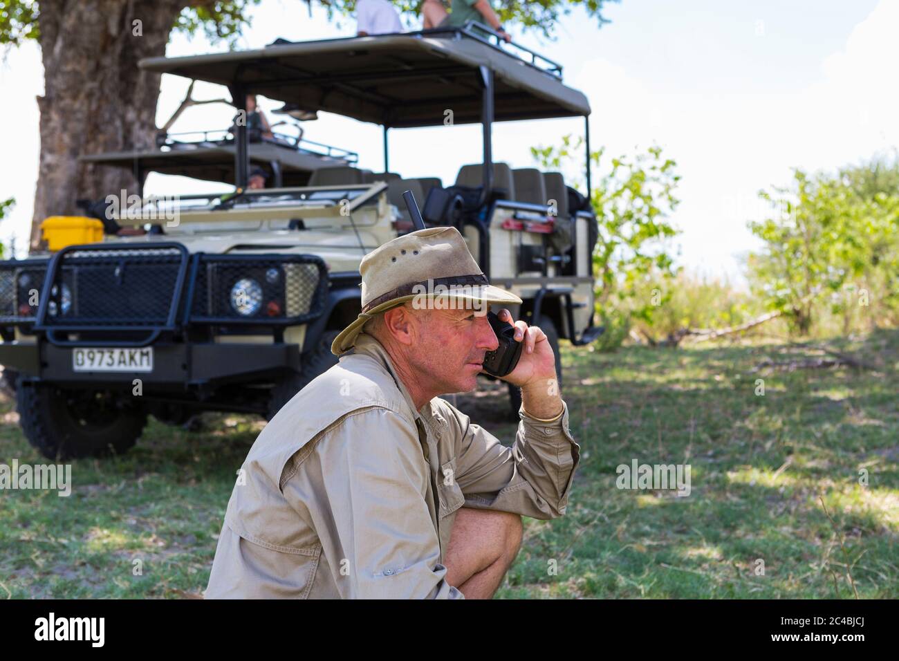A guide in a bush hat on the radio at Moremi Game Reserve, Botswana ...