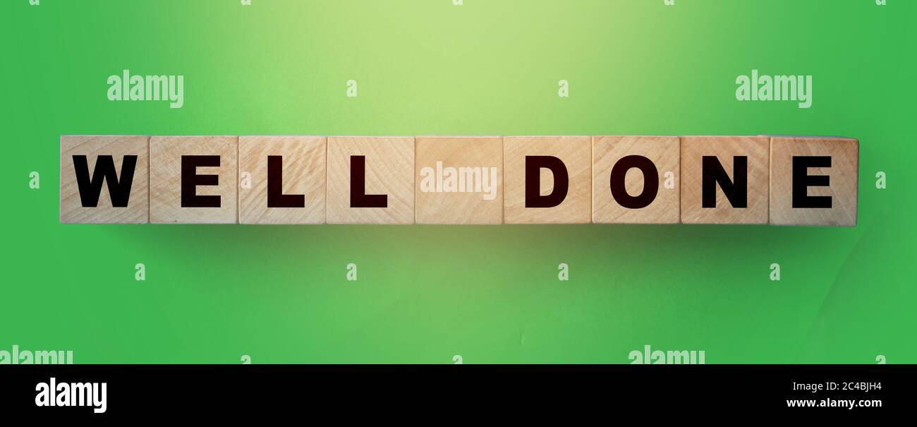 Well Done written on a wooden cubeon green. Good job great result ...