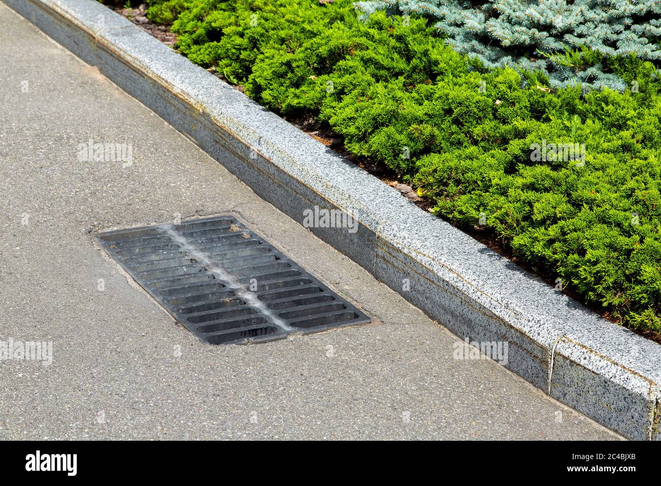 hatch storm system with a grate in the asphalt road surface with a ...