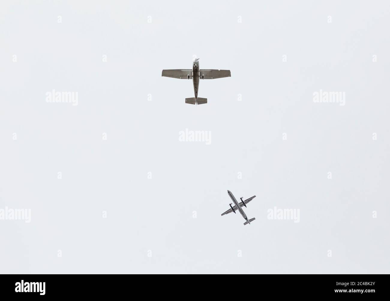 The underside of two aeroplanes flying in a grey sky Stock Photo - Alamy