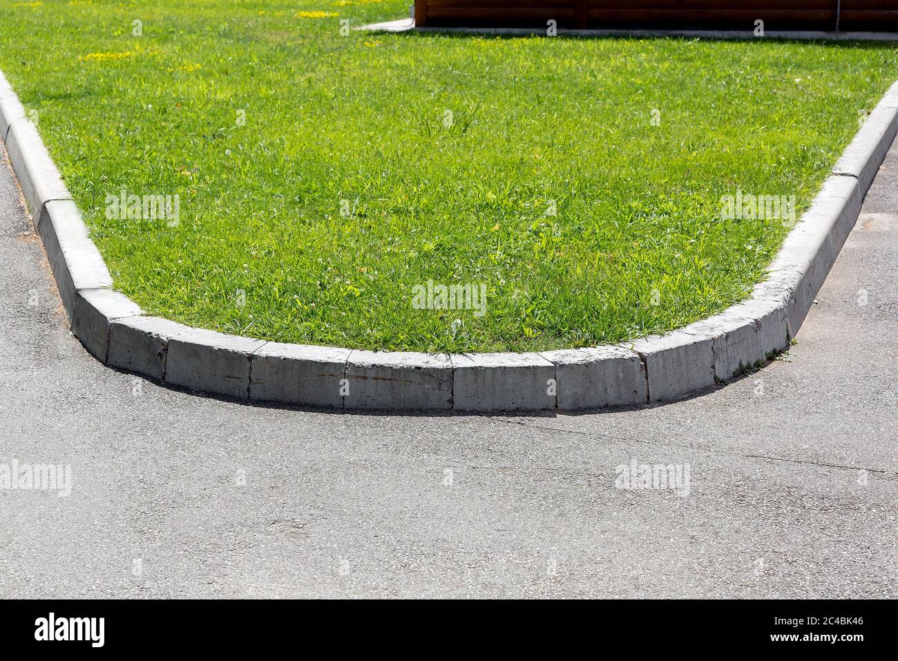 roadside of an asphalt road with a stone curb in the background lawn ...