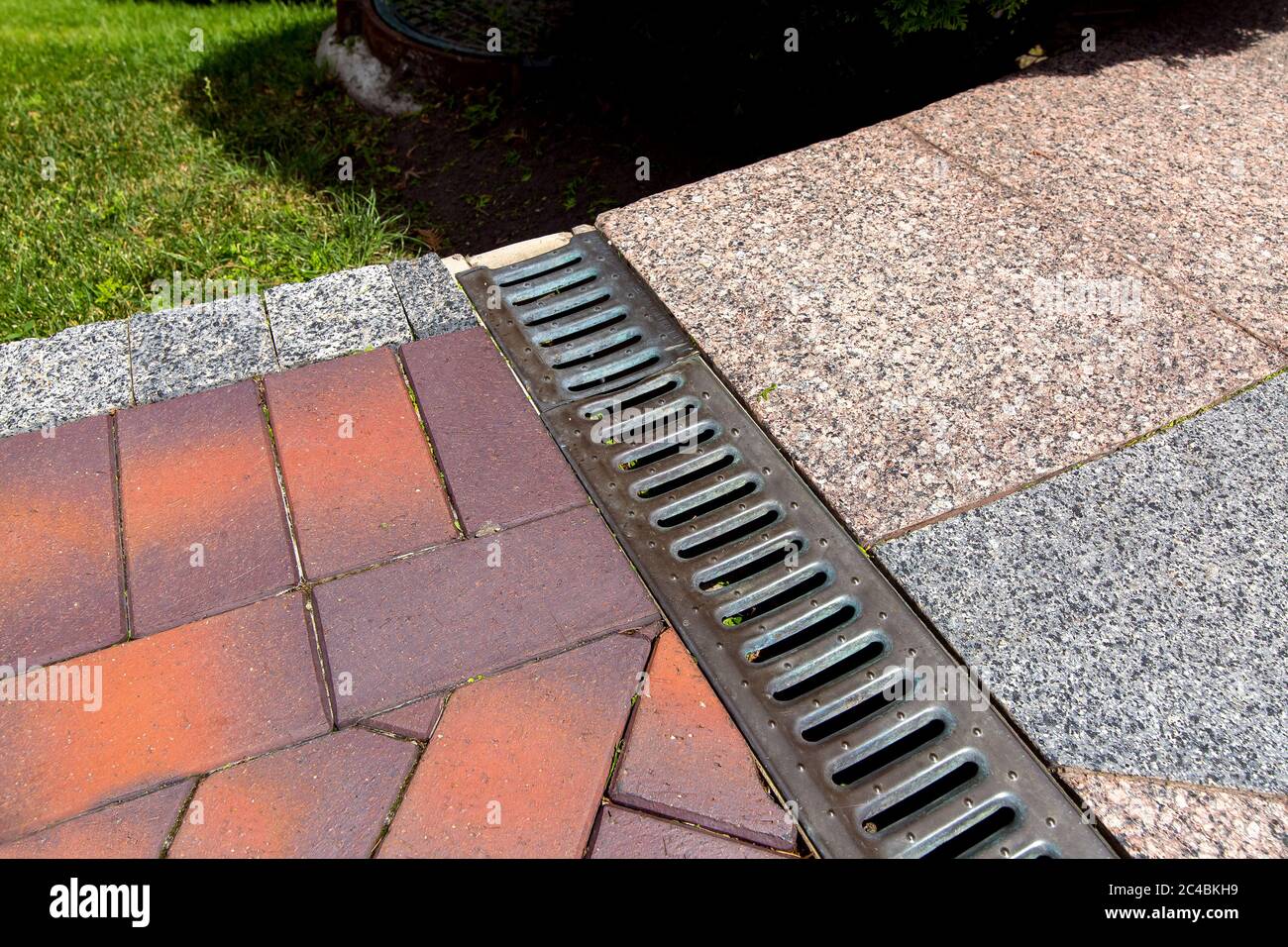 rain grate to the joints of two paths of granite and paving slabs on ...