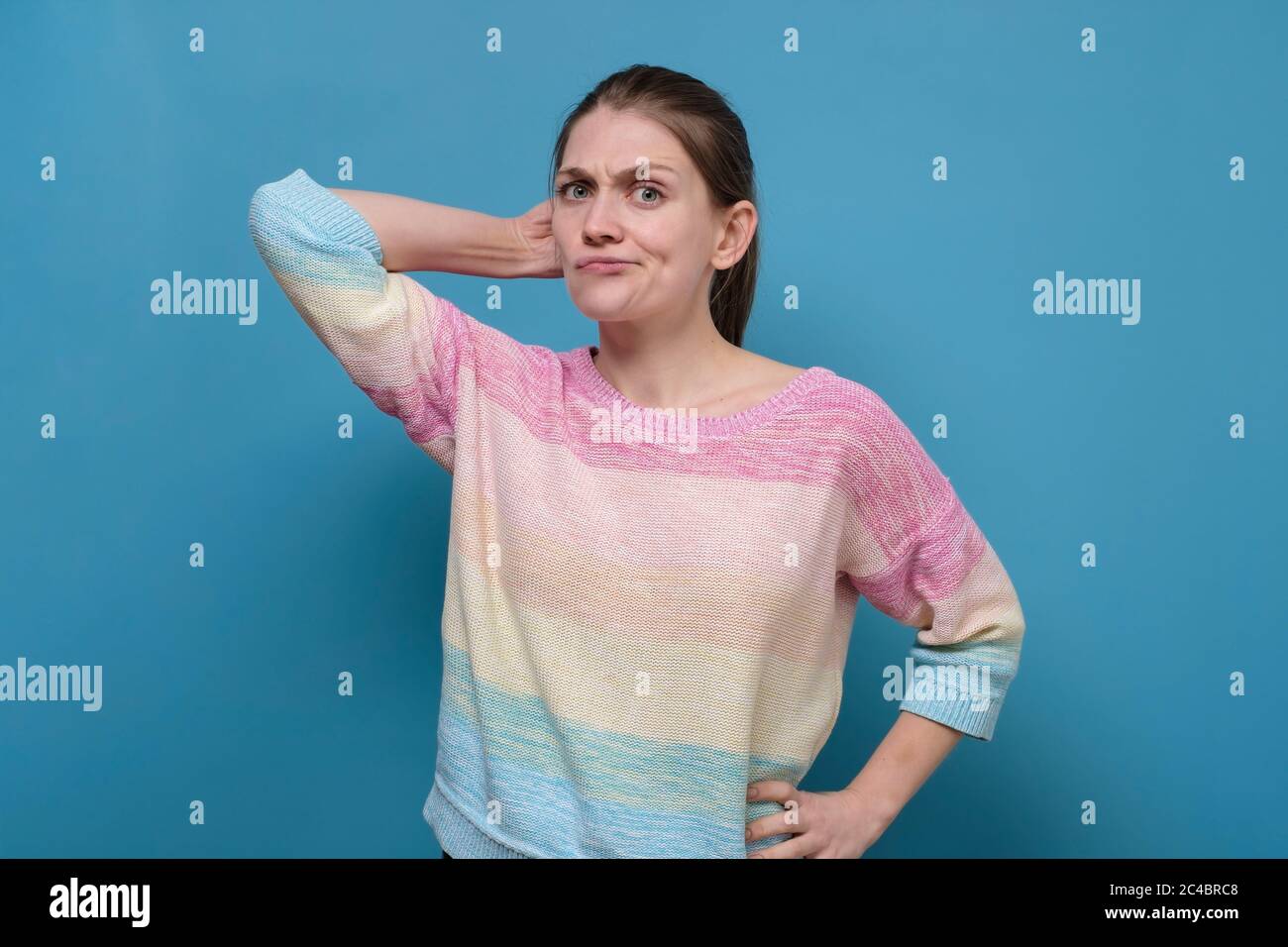 Young woman scratching head, thinking dreaming deeply about something ...