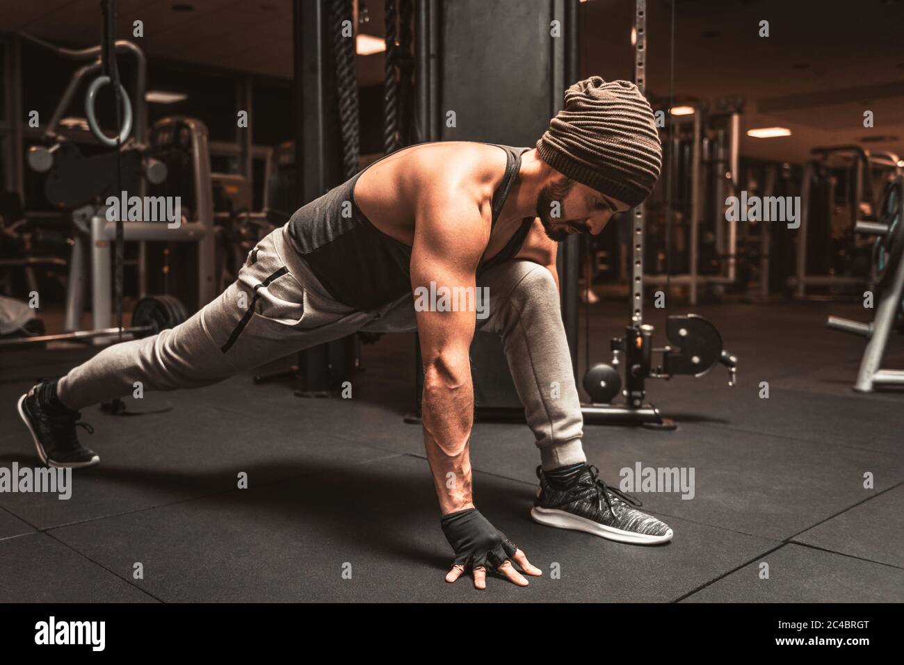 A sporty man in the gym is doing Yoga exercises. Virabhadrasana: the ...