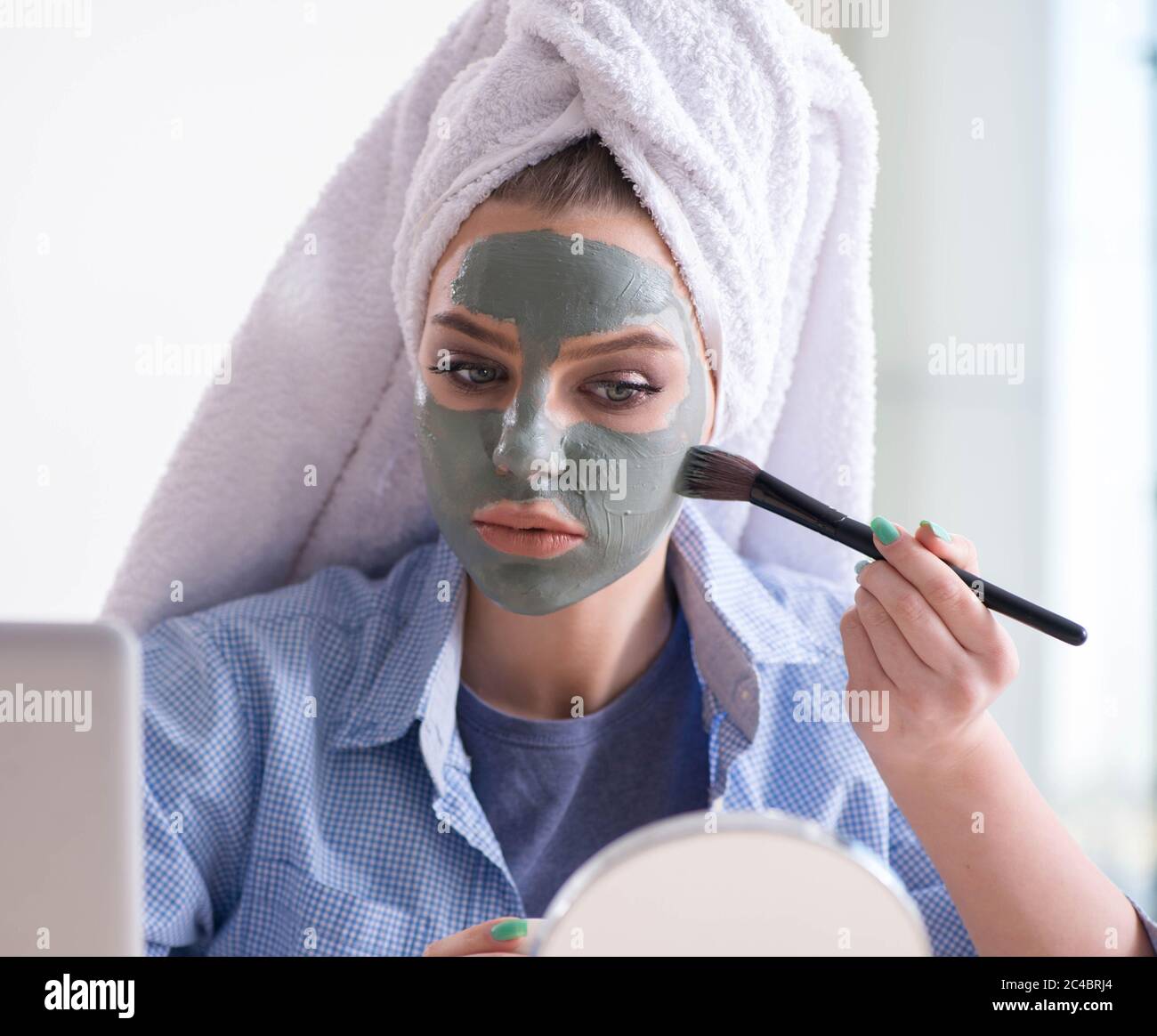 The woman applying clay mask with brush at home Stock Photo - Alamy