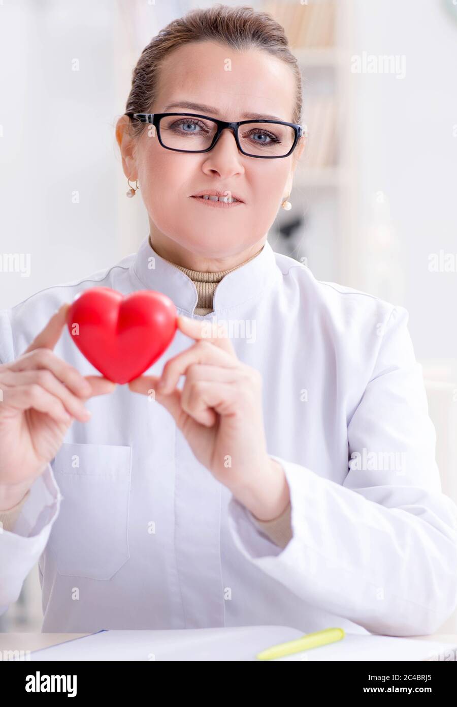 The cardiologist with red heart in medical concept Stock Photo - Alamy