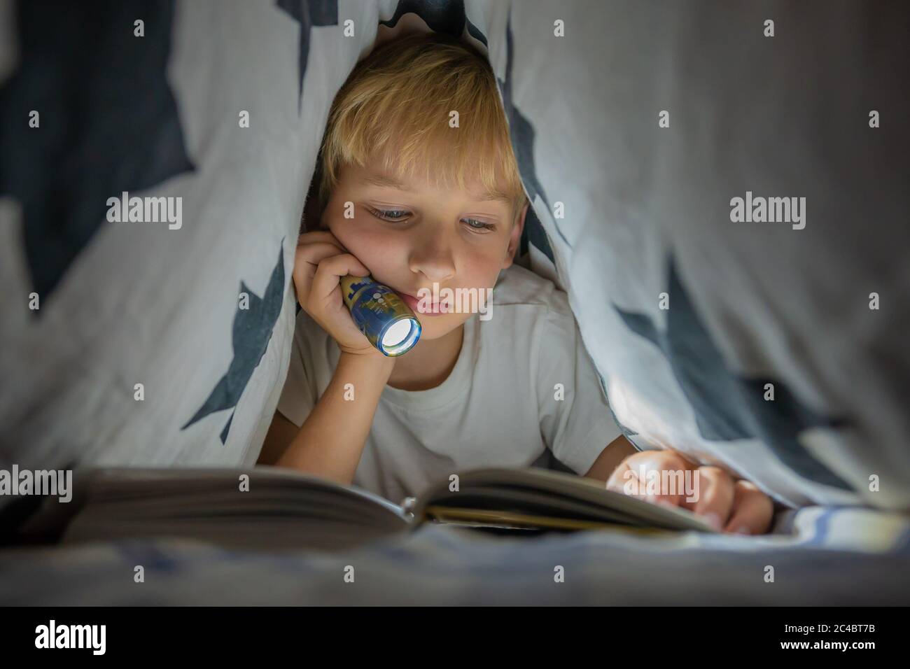 Kid reading a book with flashlight hi-res stock photography and images ...