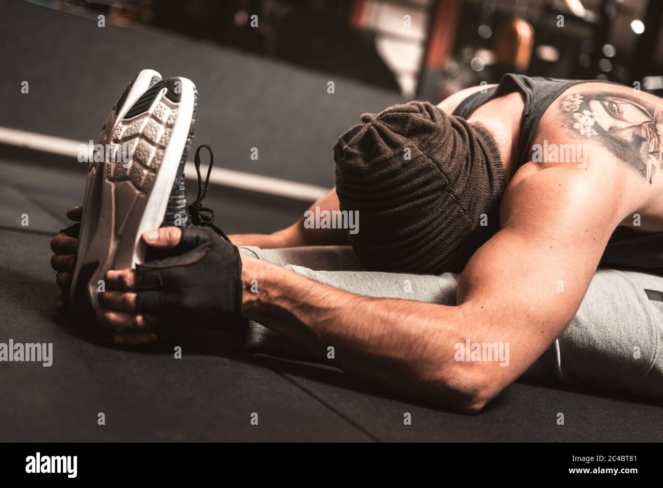 A sporty man in the gym is doing Yoga exercises. Paschimottanasana ...