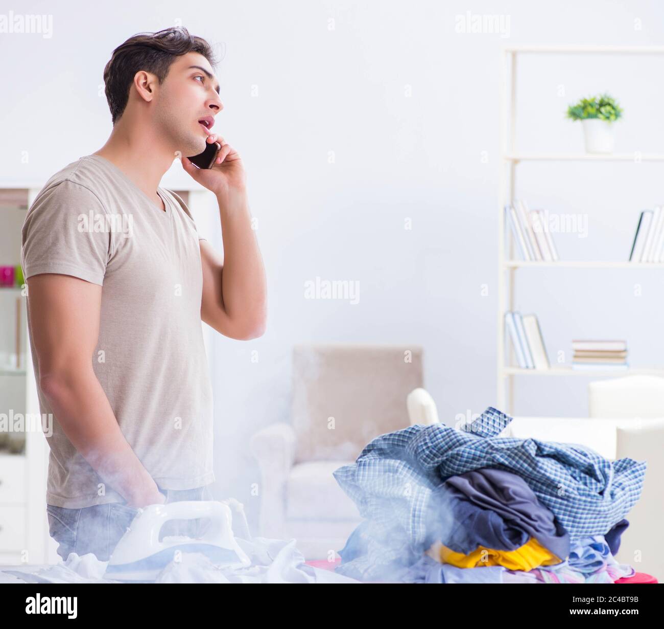 The inattentive husband burning clothing while ironing Stock Photo - Alamy