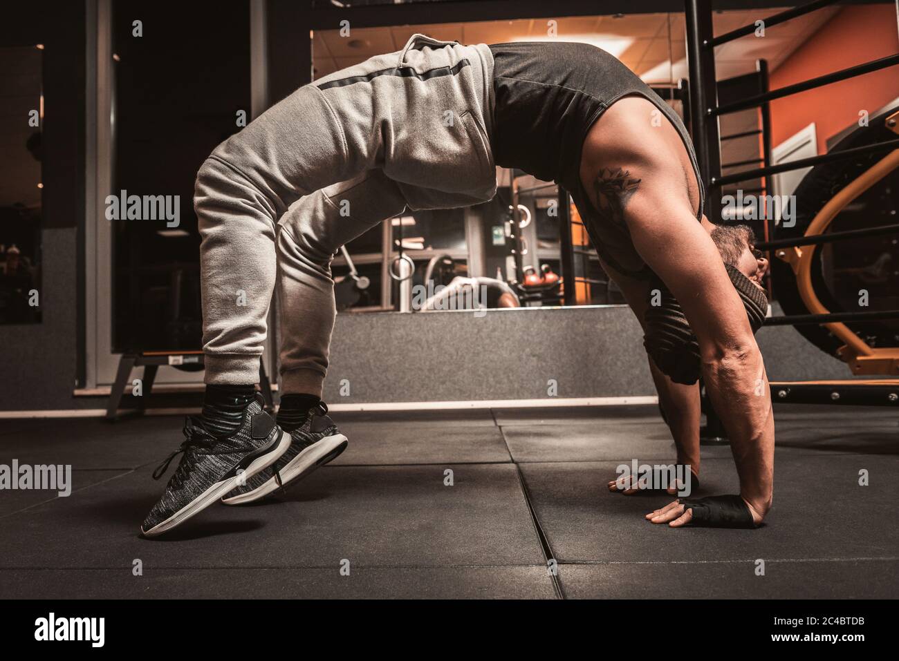 A sporty man in the gym is doing Yoga exercises. Chakrasana or Urdhva ...