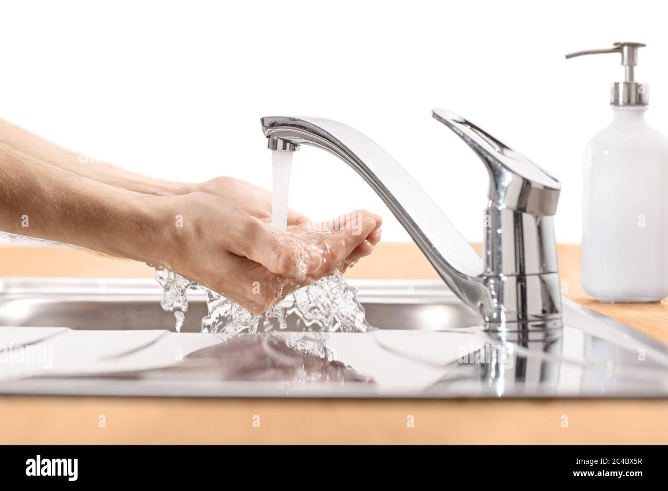 Male hands washing under water in a sink isolated on white background ...