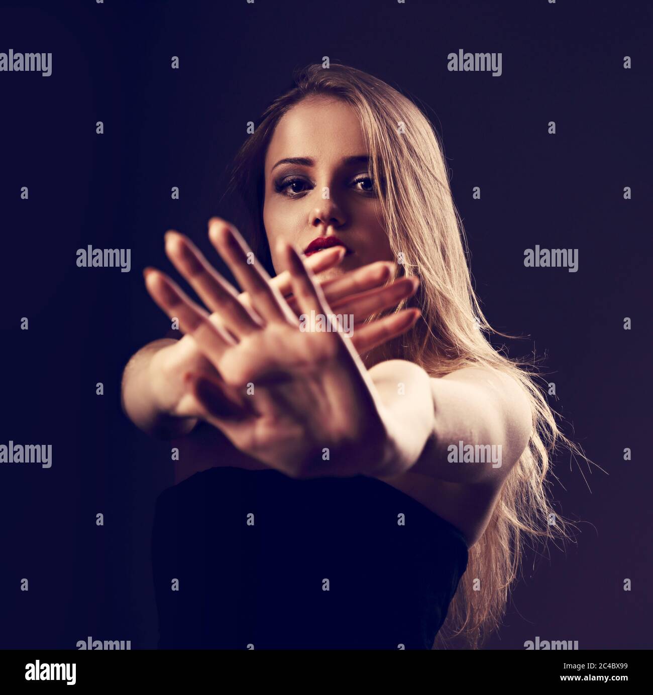 Angry female blond model showing the hands and signaling to stop ...