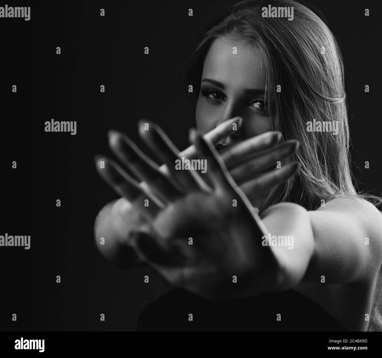 Angry young female blond model showing the hands and signaling to stop ...