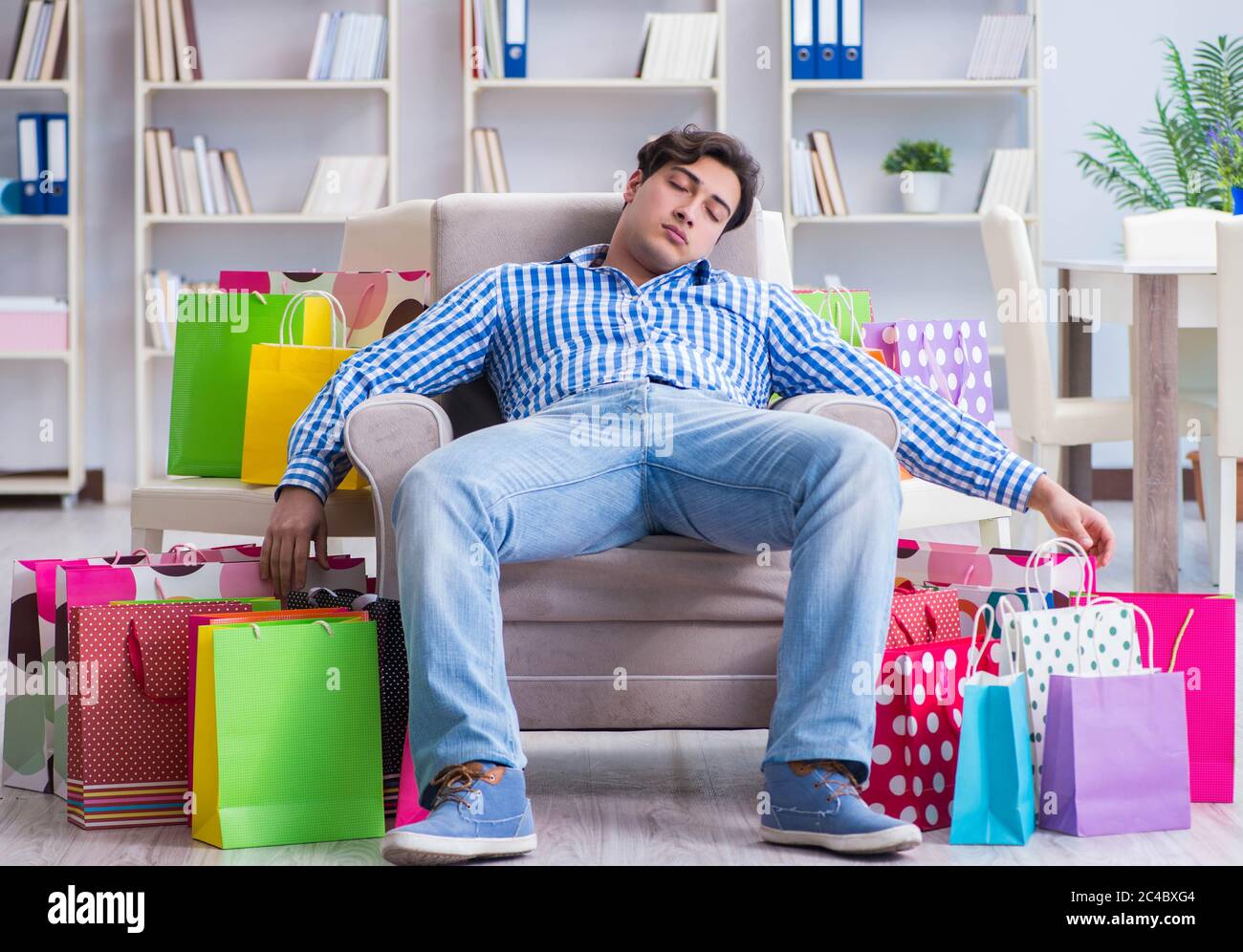 The young man after excessive shopping at home Stock Photo - Alamy