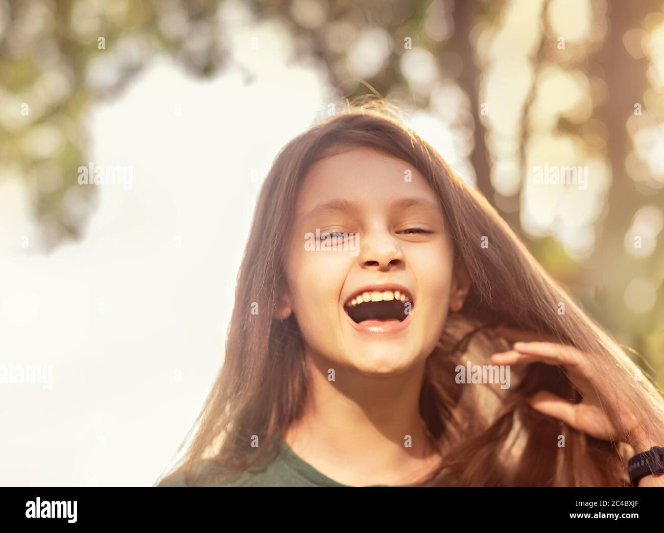 Happy loud laughing casual kid girl on nature summer background ...