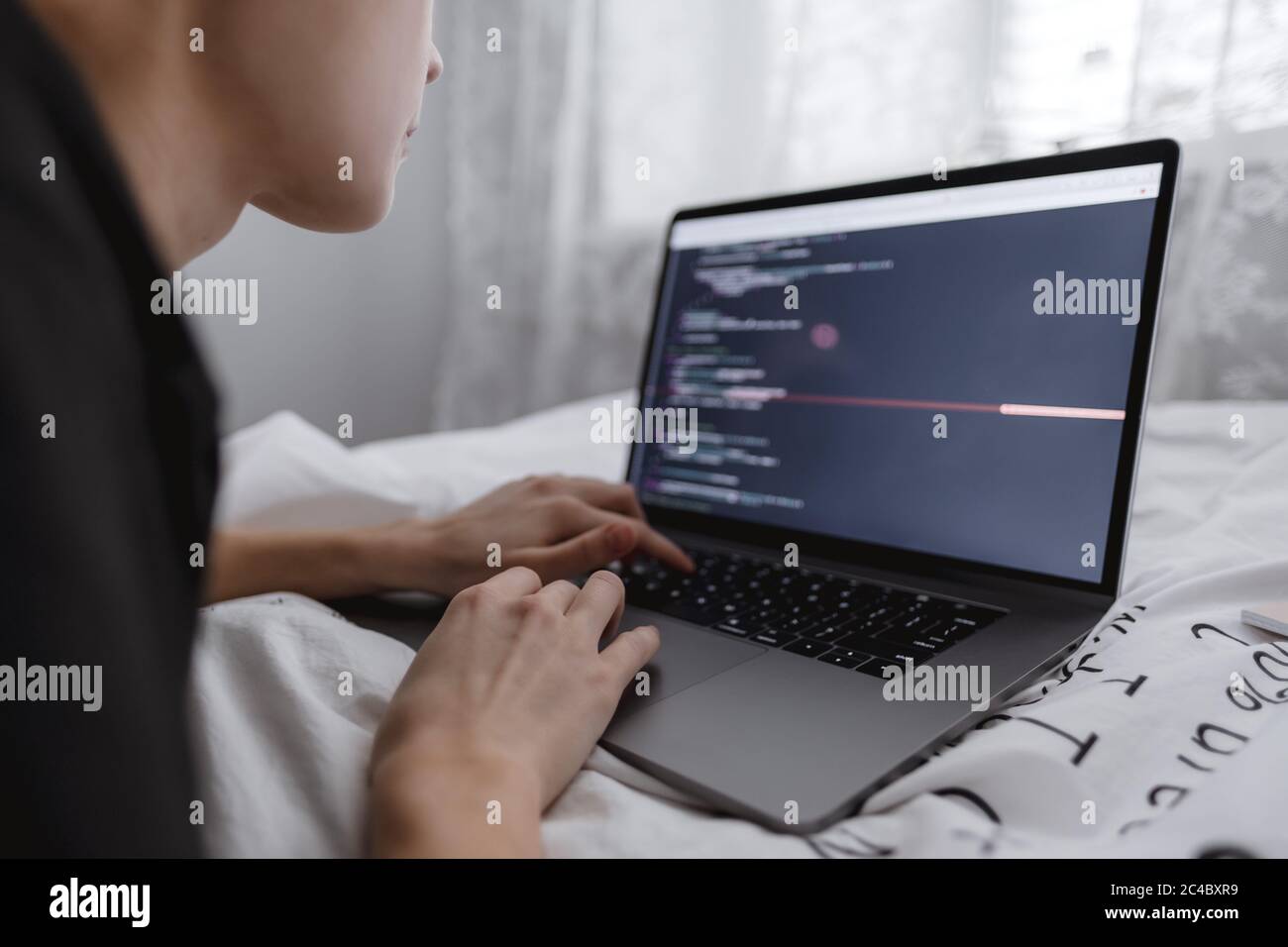 Young female programmer writes program code on a computer laptop in the ...