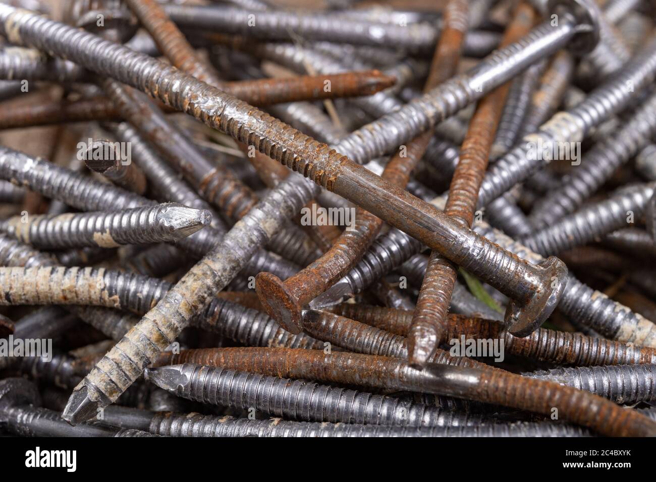 A pile of rusty nails. Old metal elements in a home workshop. Dark ...