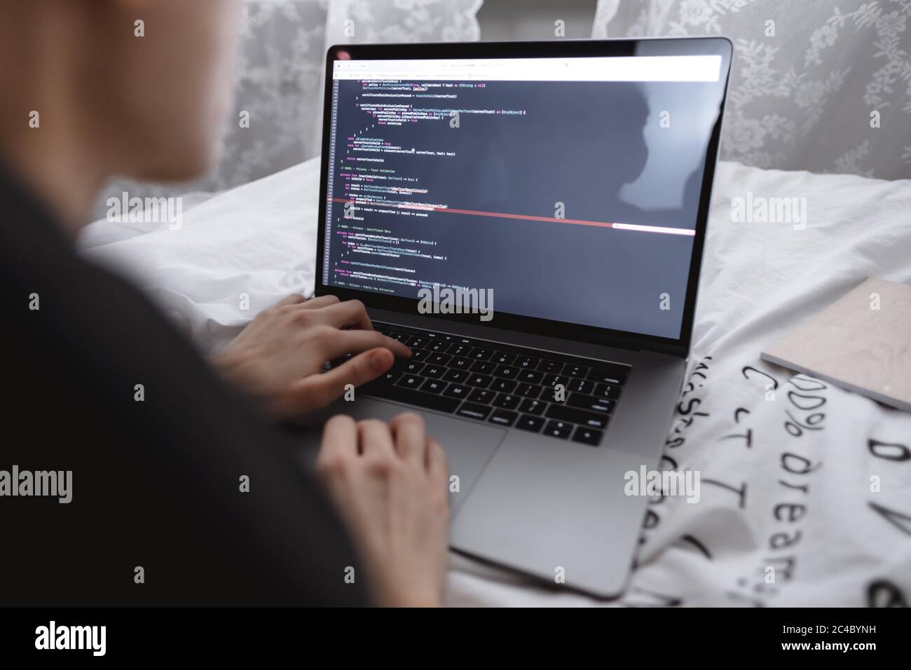 Young female programmer writes program code on a computer laptop in the ...
