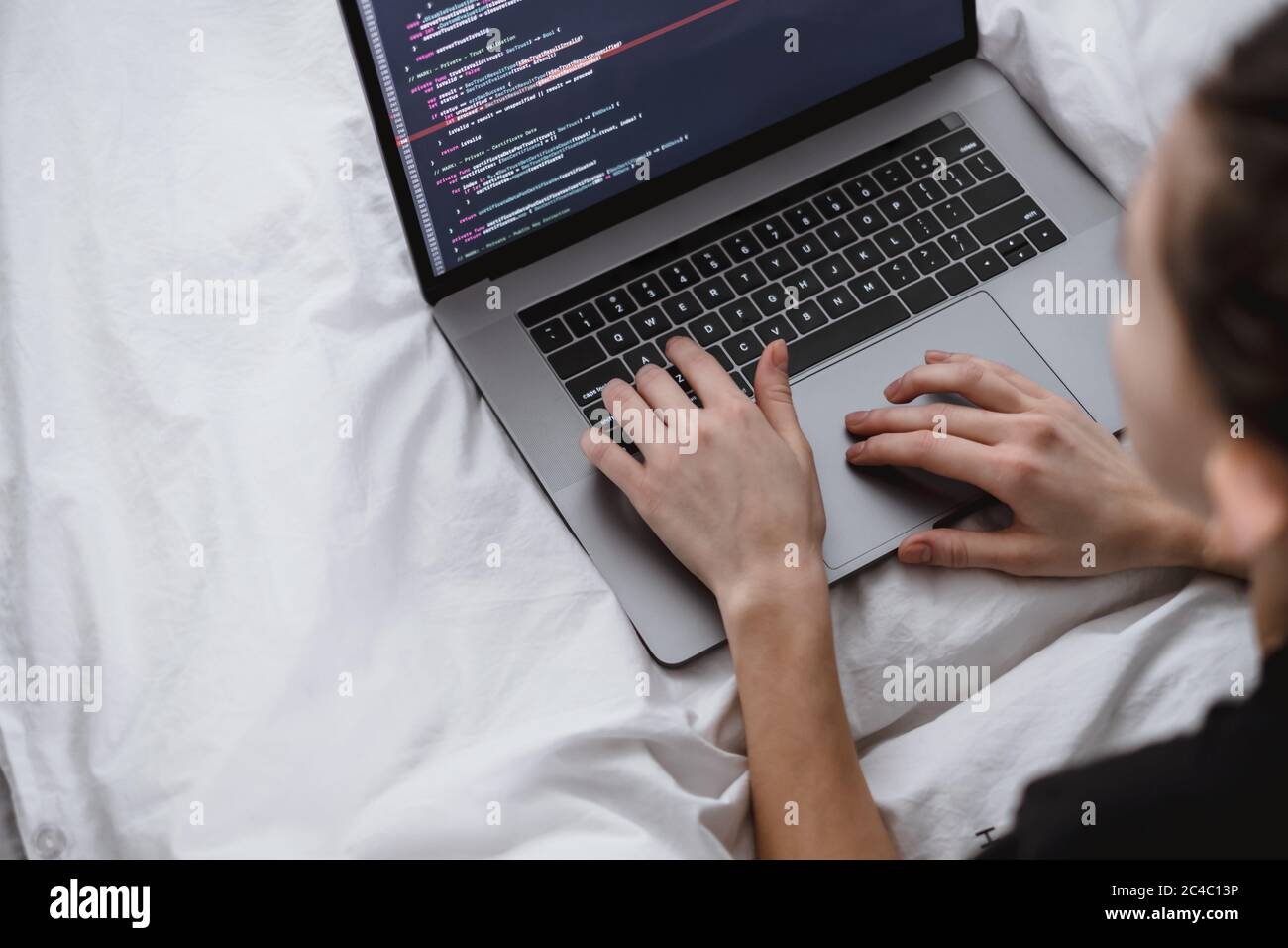 Young female programmer writes program code on a computer laptop in the ...