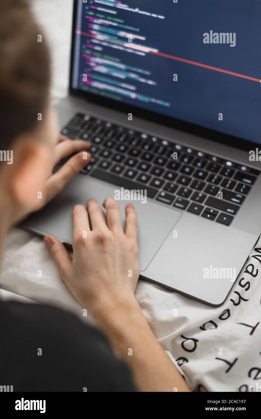 Young female programmer writes program code on a computer laptop in the ...